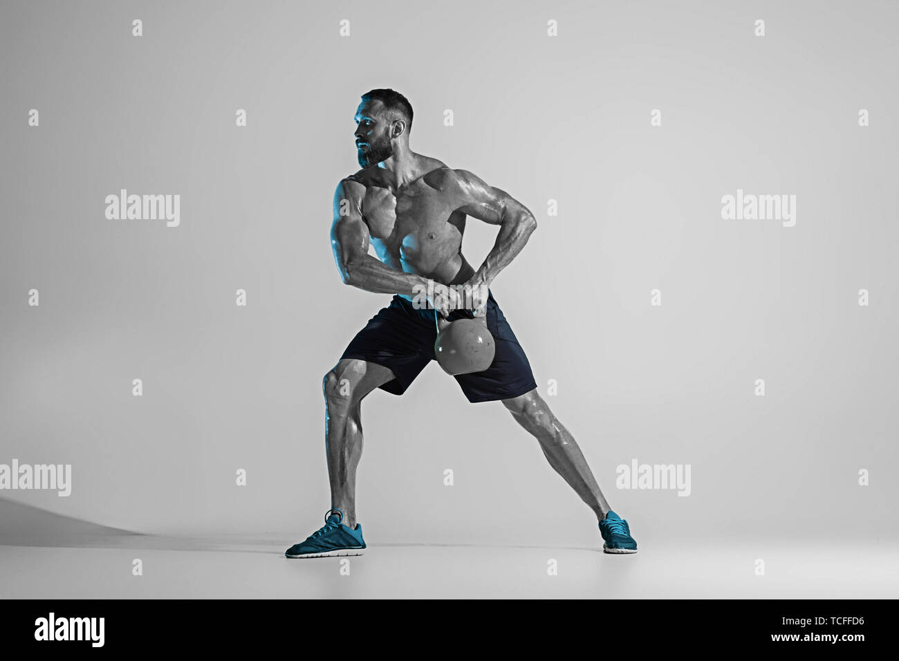 To the best self. Young caucasian bodybuilder training over studio ...