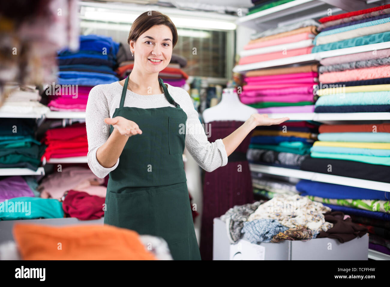 Female shop assistant demonstrating assortment at drapery shop Stock ...