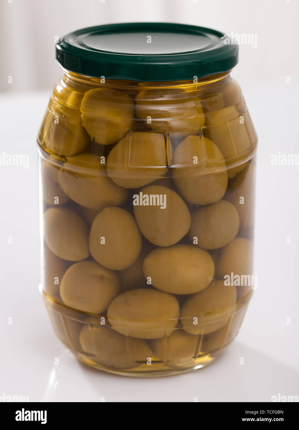 Glass jar of green unpitted olives in brine on white background Stock ...
