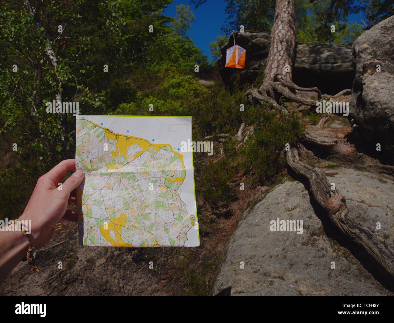 Athlete hand hold typical chart for orienteering sports. Person marks ...