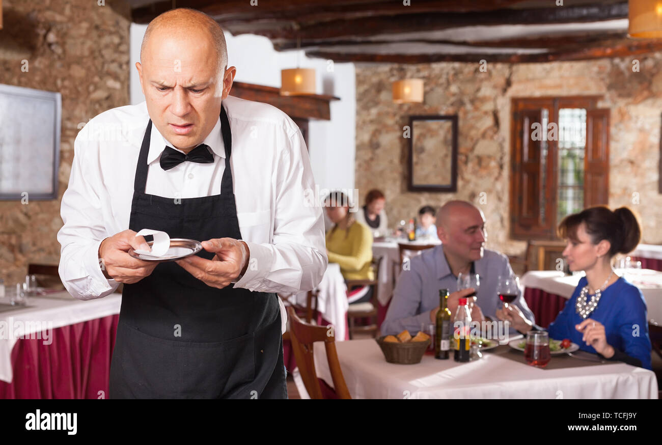 Male waiter demonstrating his upset with little tips from restaurant ...