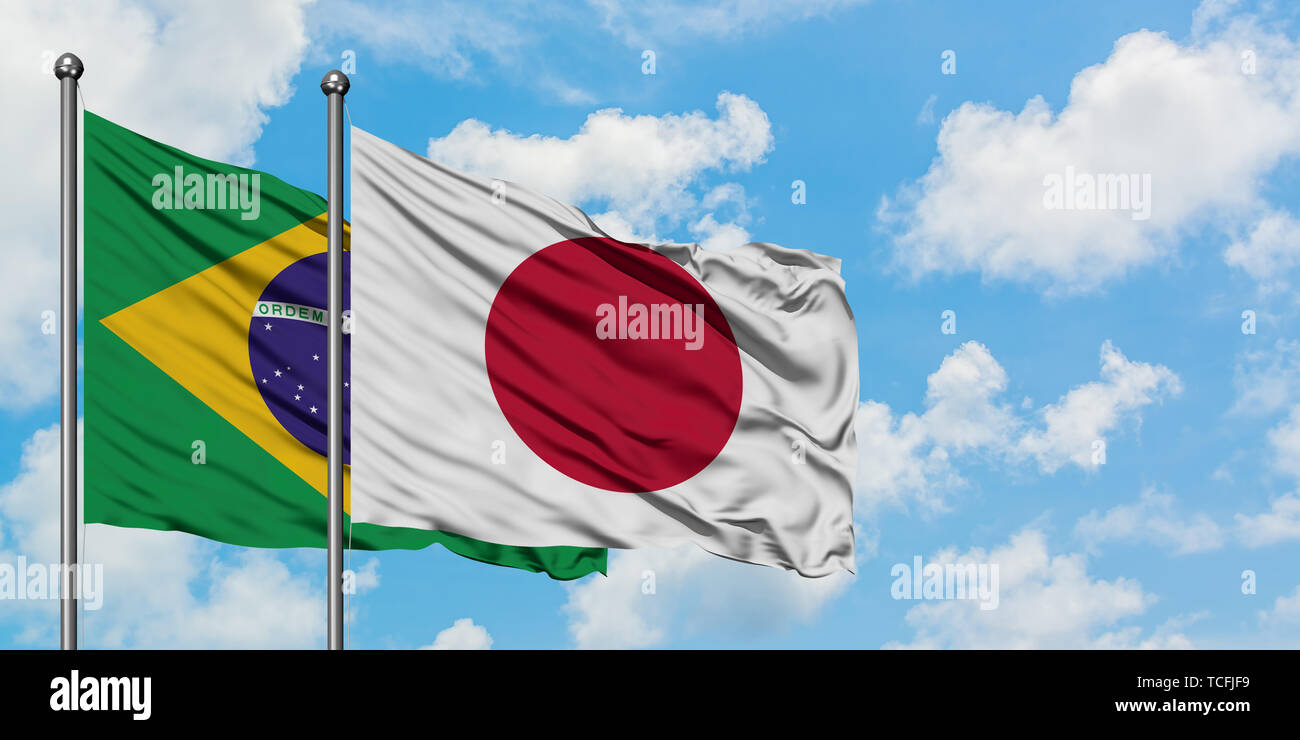 Brazil and Japan flag waving in the wind against white cloudy blue sky ...