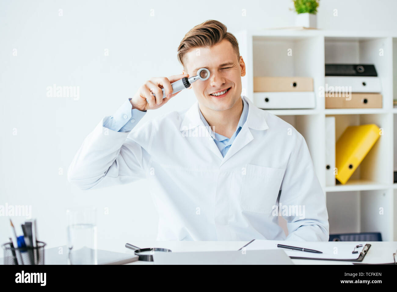 happy dermatologist in white coat holding dermatoscope and smiling in ...