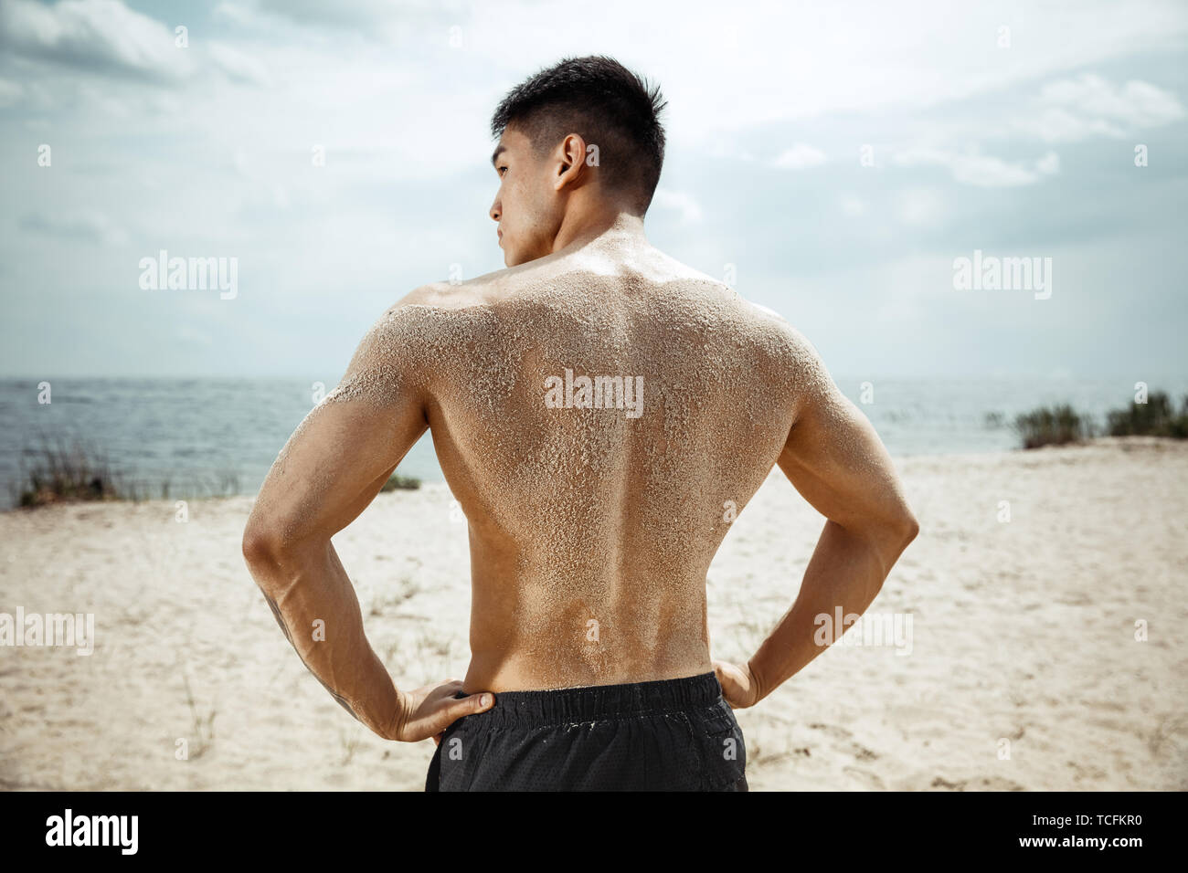 Young healthy man athlete doing exercise at the beach. Signle male ...