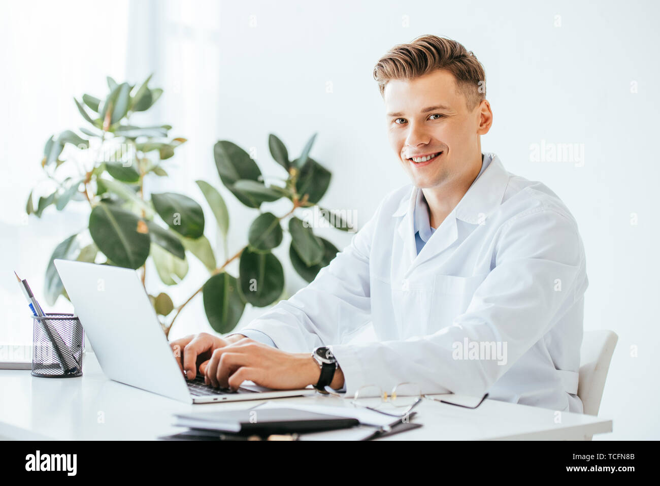 Doctor looking camera using laptop hi-res stock photography and images ...