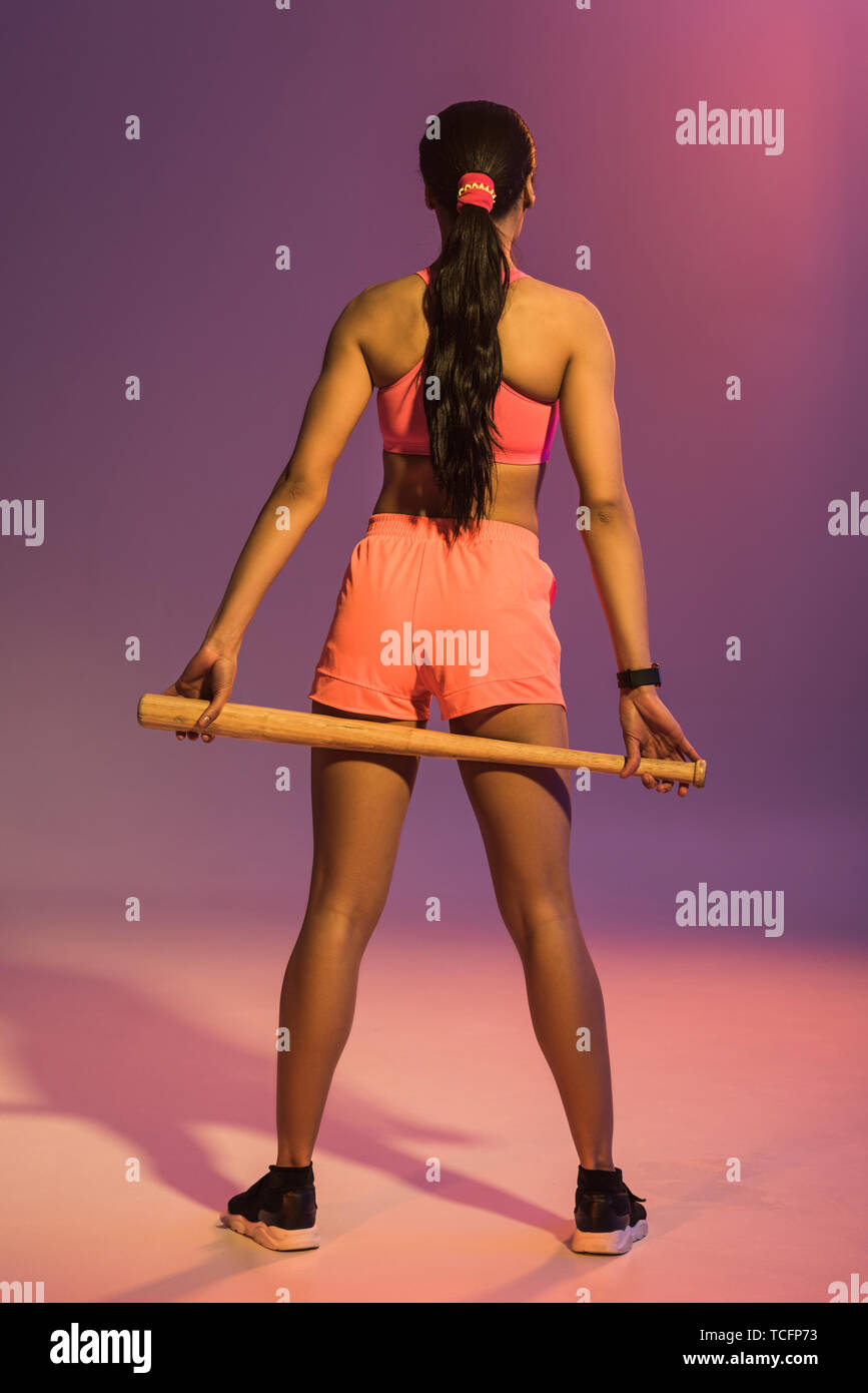 back view of sportive african american girl holding baseball bat on ...