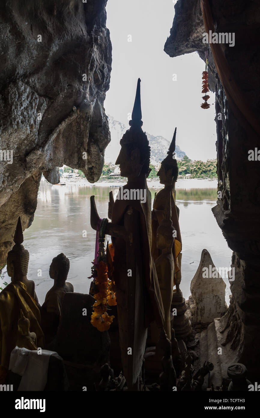 Hundreds of old and faded Buddha statues inside the Tham Ting Cave at ...