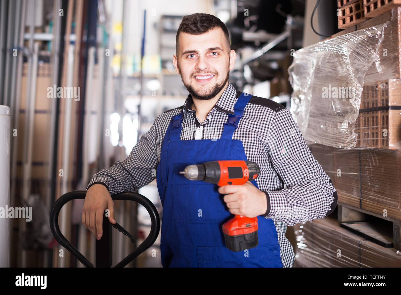 Young smiling guy displaying his professional tools at workshop Stock ...