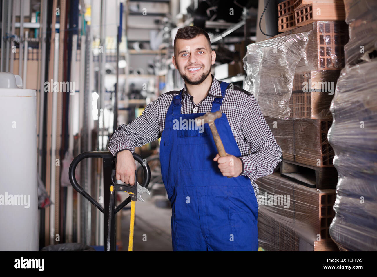 Smiling working man demonstrating various tools at workshop Stock Photo ...