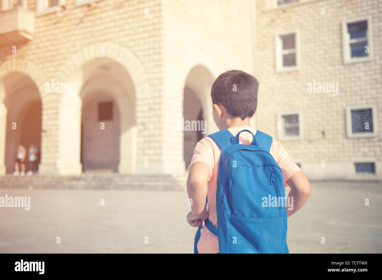 Back to school first day kid carrying backpack walking up school stairs ...