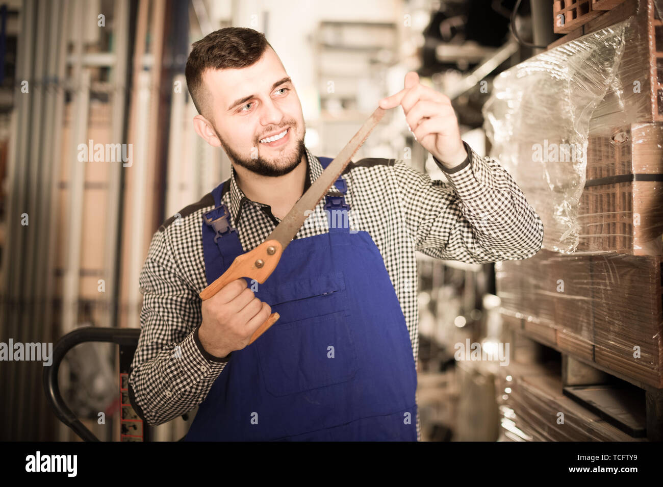 Positive worker man showing various tools at workplace Stock Photo - Alamy