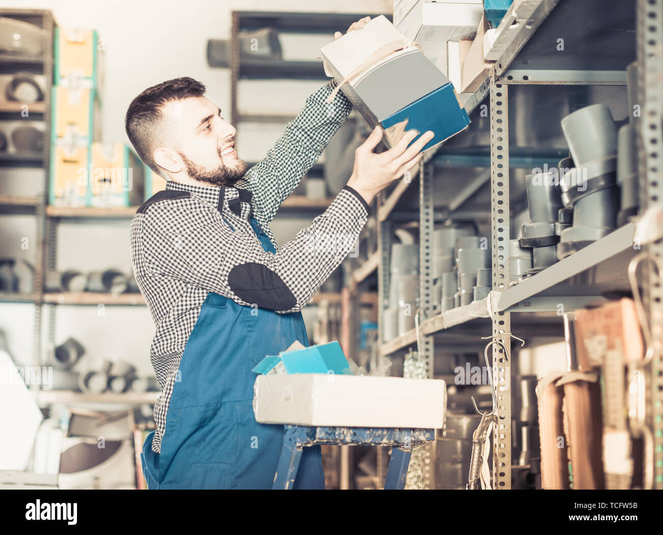 Young guy takes out a box with small items for repair by a tear in the ...