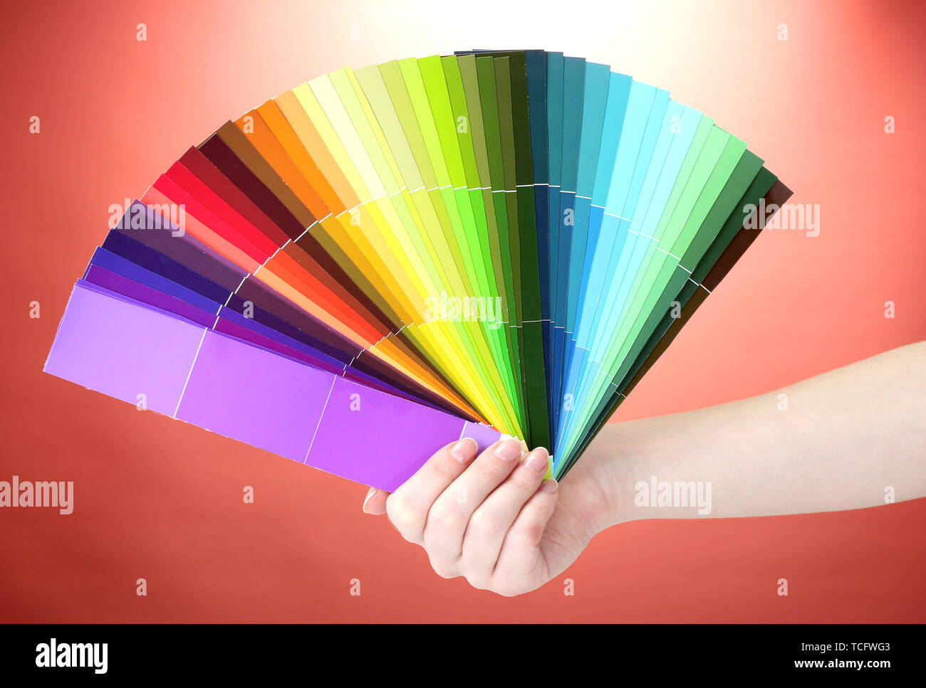 hand holding bright palette of colors on red background Stock Photo - Alamy