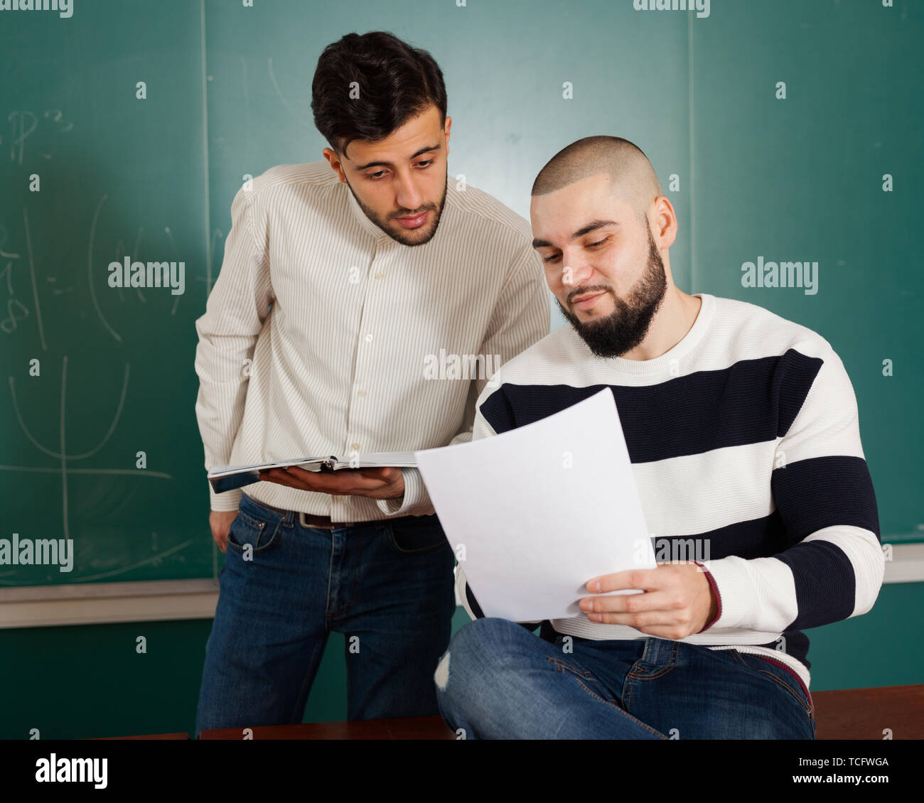 Two young handsome students having discussion about their university ...