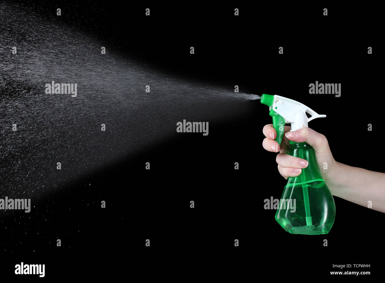hand holding spray bottle and spraying on black background Stock Photo ...