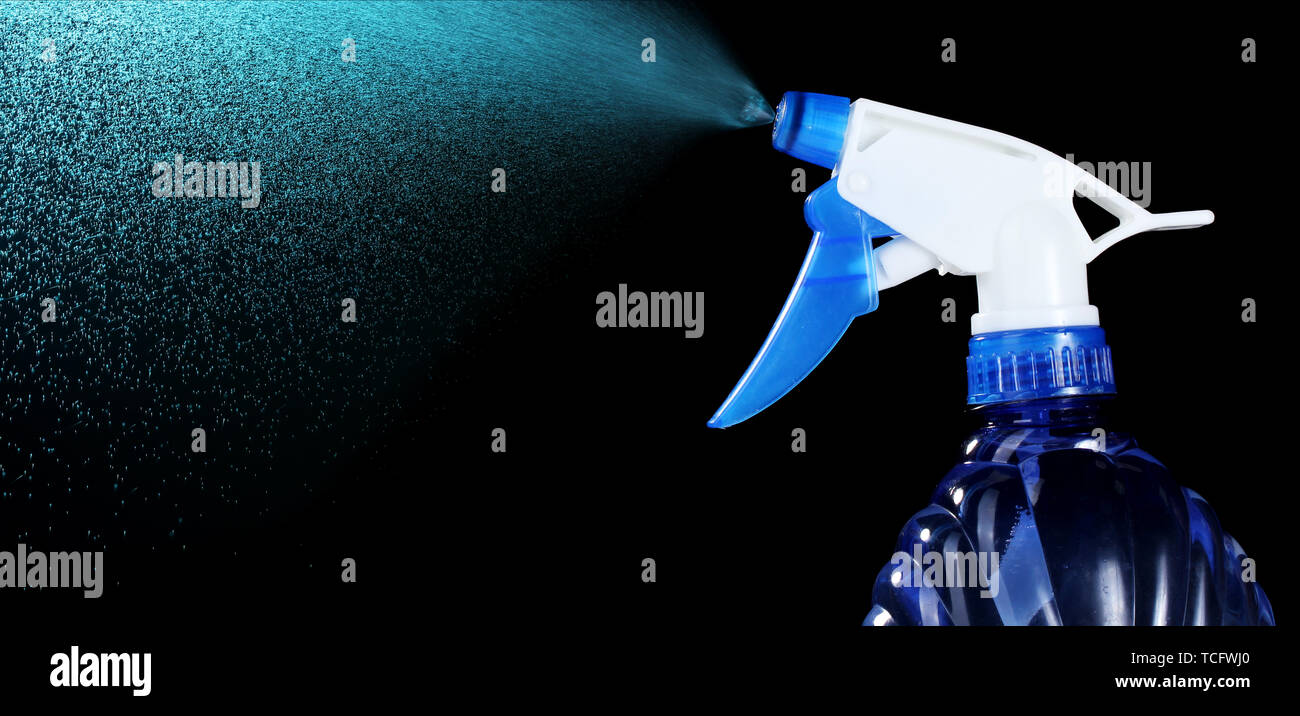 hand holding spray bottle and spraying on black background Stock Photo ...