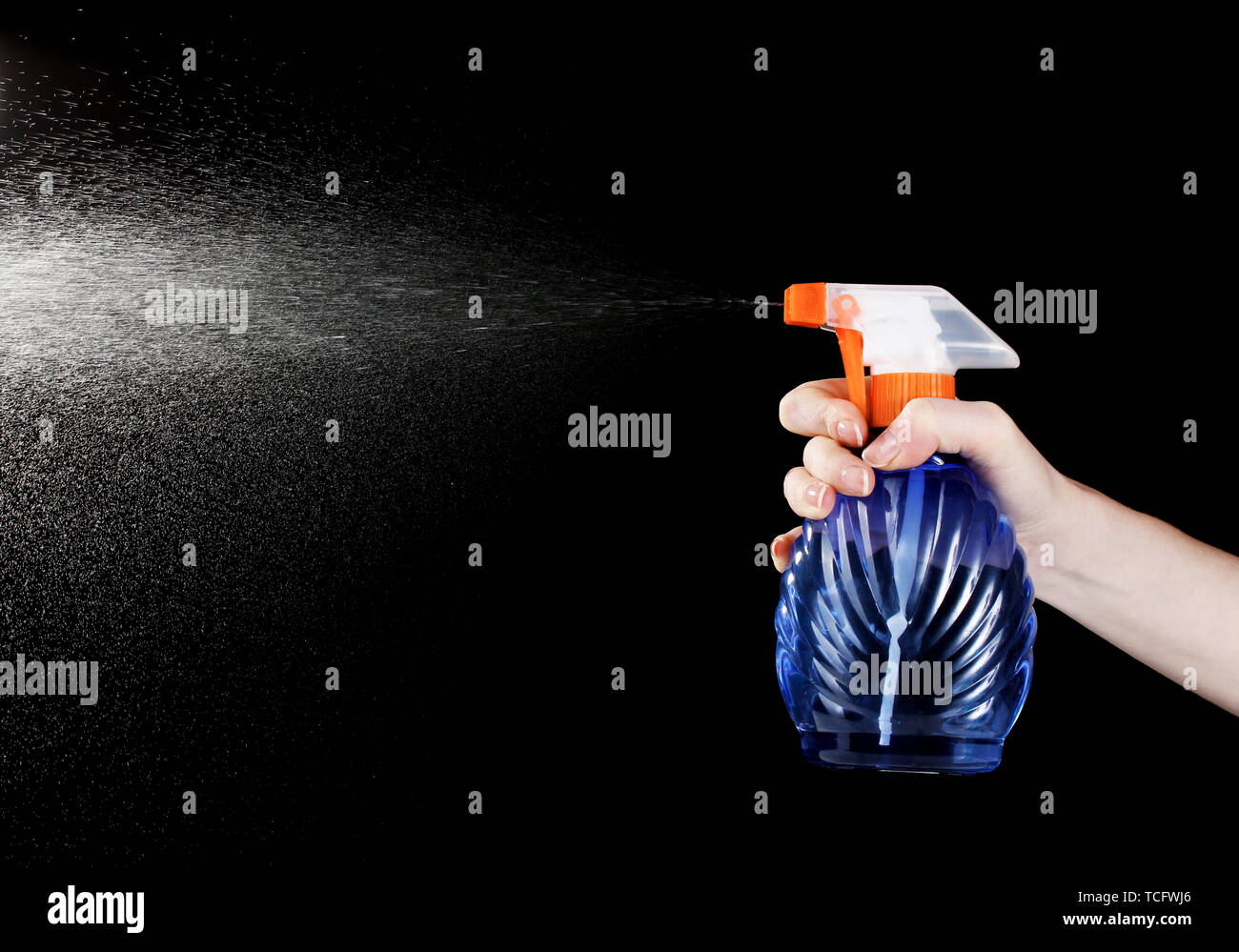 hand holding spray bottle and spraying on black background Stock Photo ...
