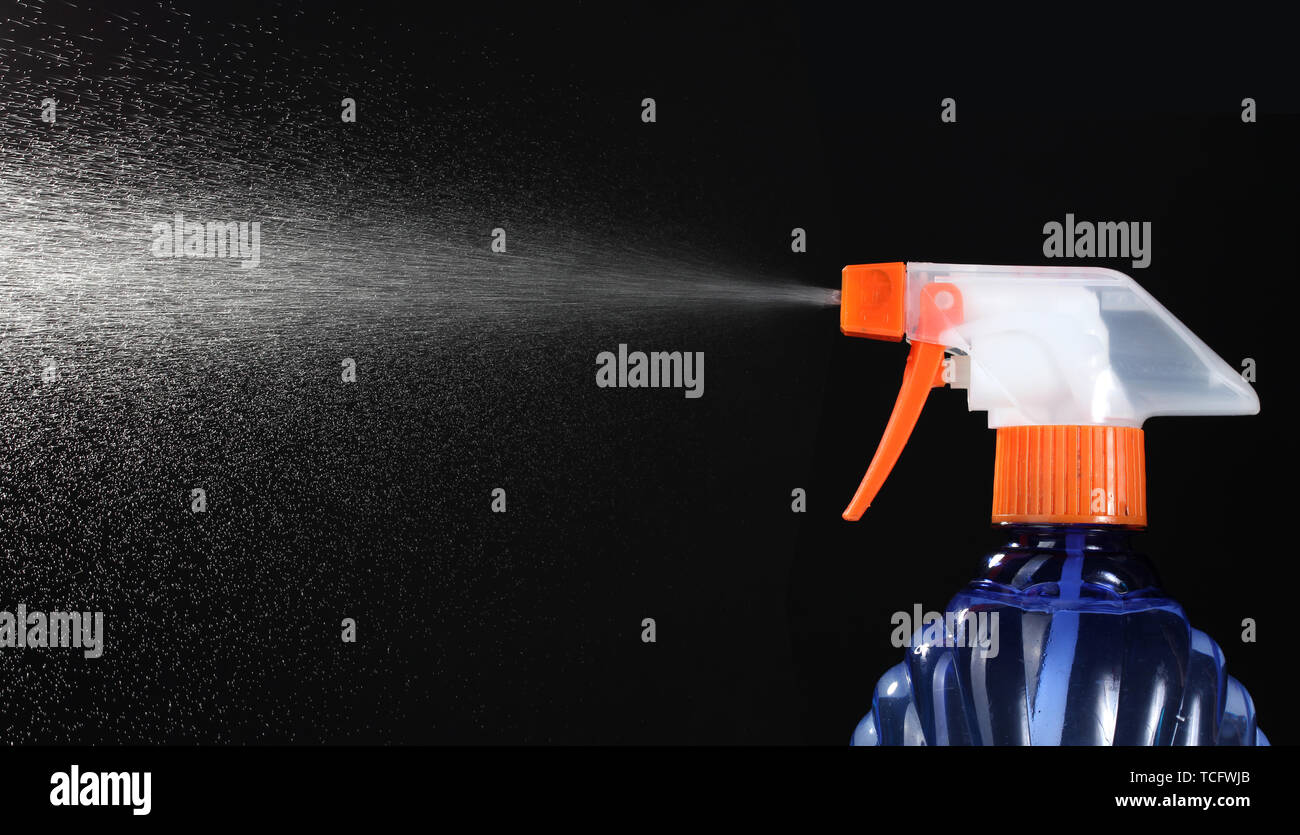 spray bottle and spraying on black background Stock Photo - Alamy