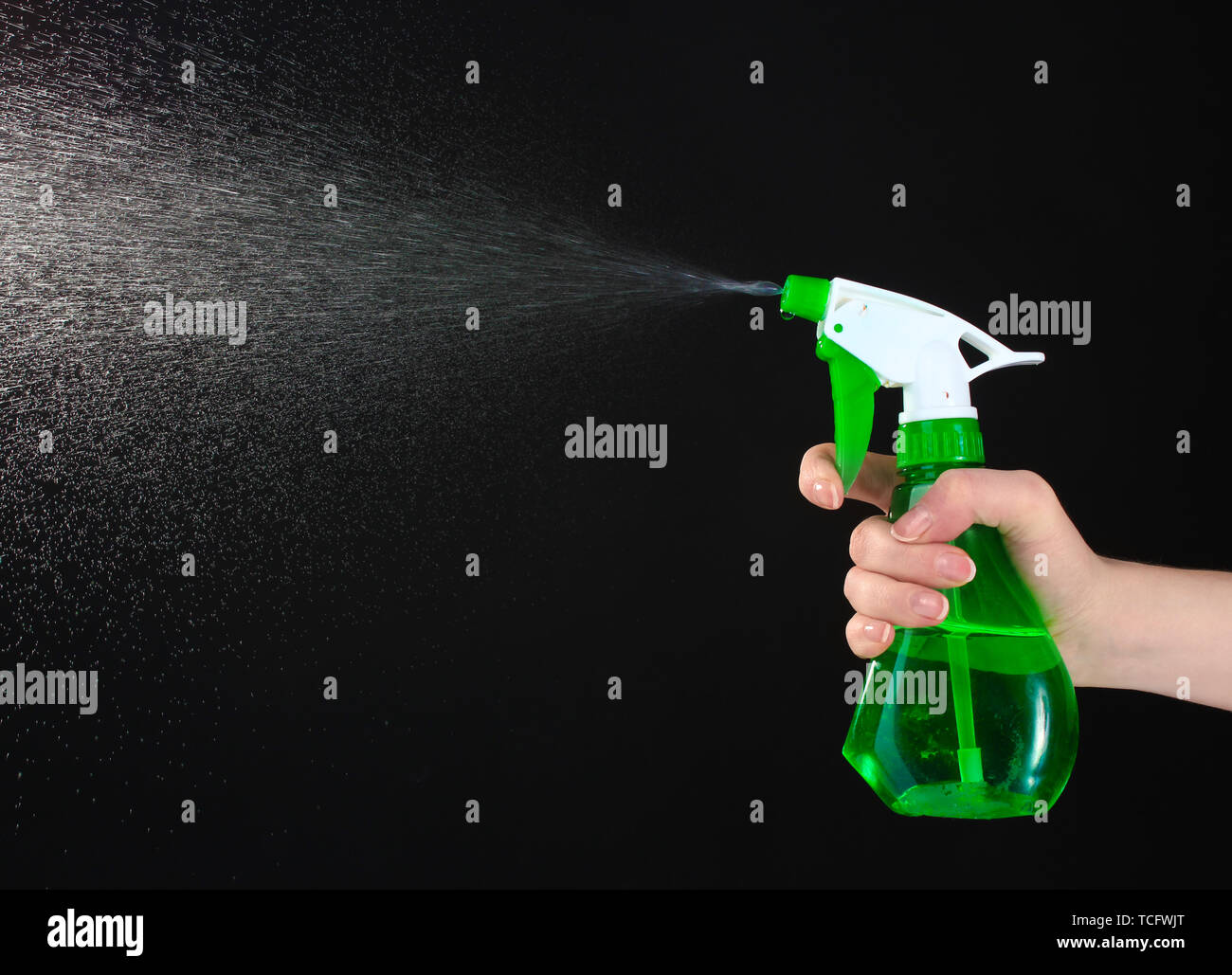 hand holding spray bottle and spraying on black background Stock Photo ...
