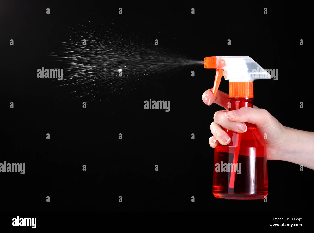 hand holding spray bottle and spraying on black background Stock Photo ...