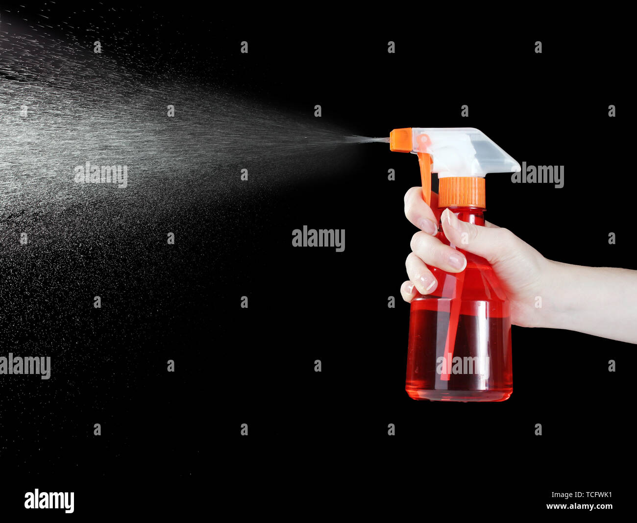 hand holding spray bottle and spraying on black background Stock Photo ...