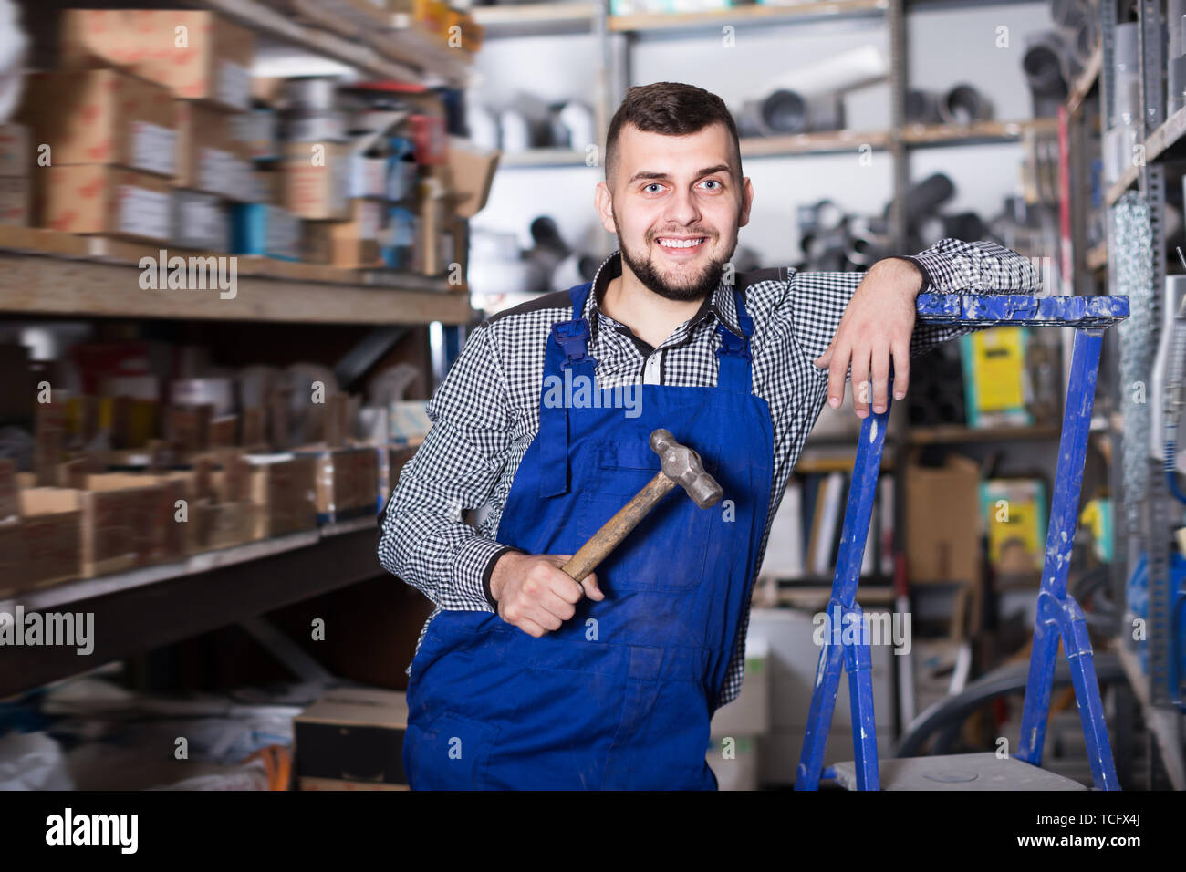 Positive male worker showing his working tools at workshop Stock Photo ...