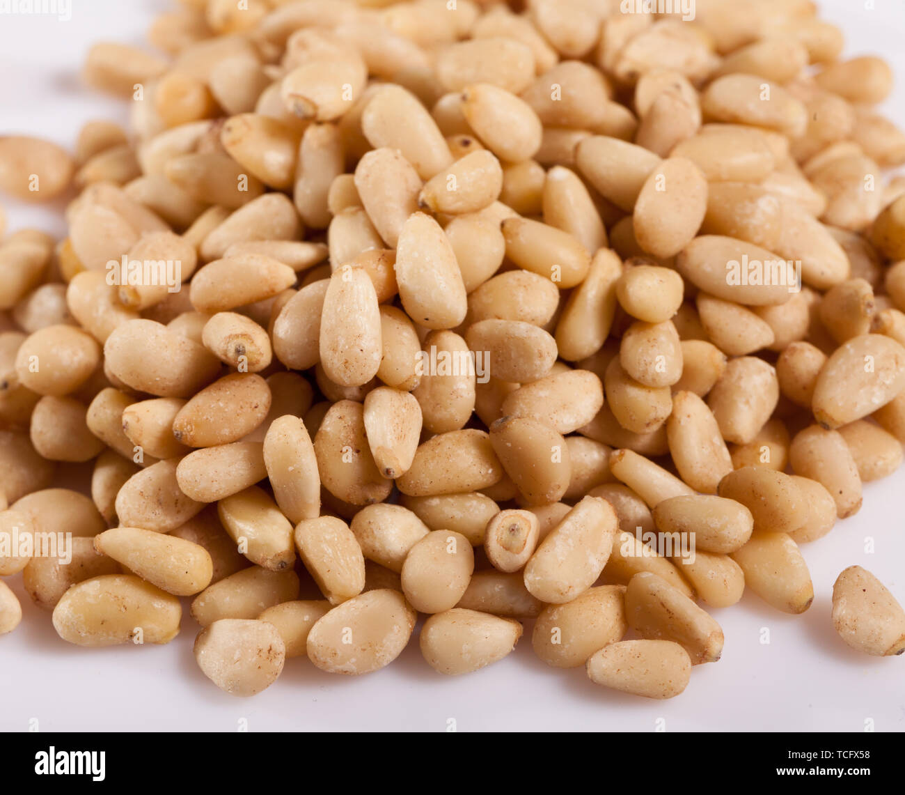 Healthy snack. Heap of shelled pine nuts on white background Stock ...