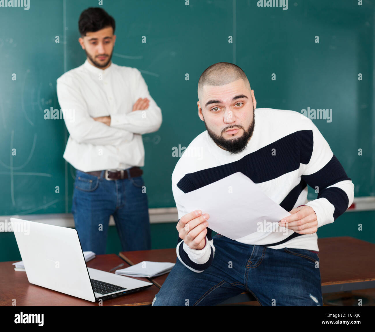 Portrait of two young guys working on their student project near ...