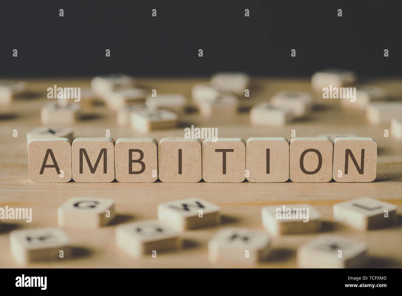 selective focus of cubes with word ambition surrounded by blocks with ...