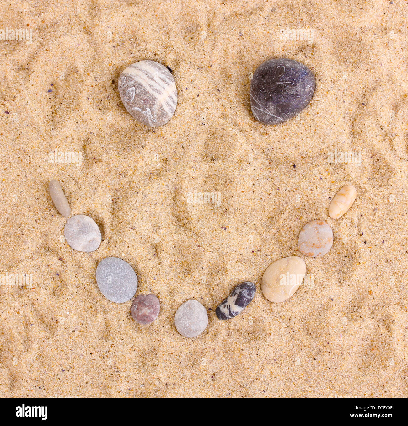 Smile-stones on sand Stock Photo - Alamy