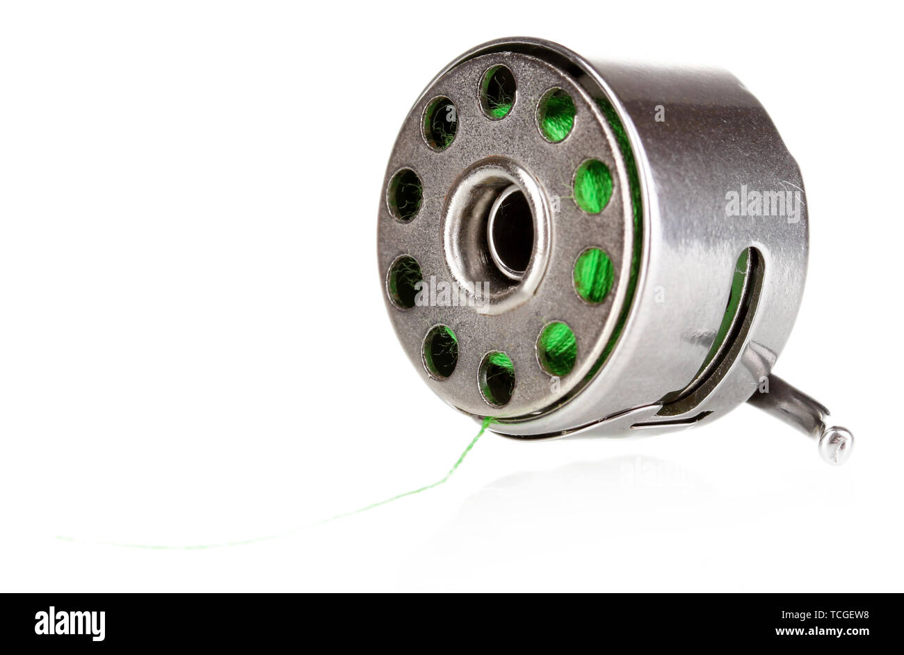 Metal spool of thread and sewing machine shuttle isolated on white ...