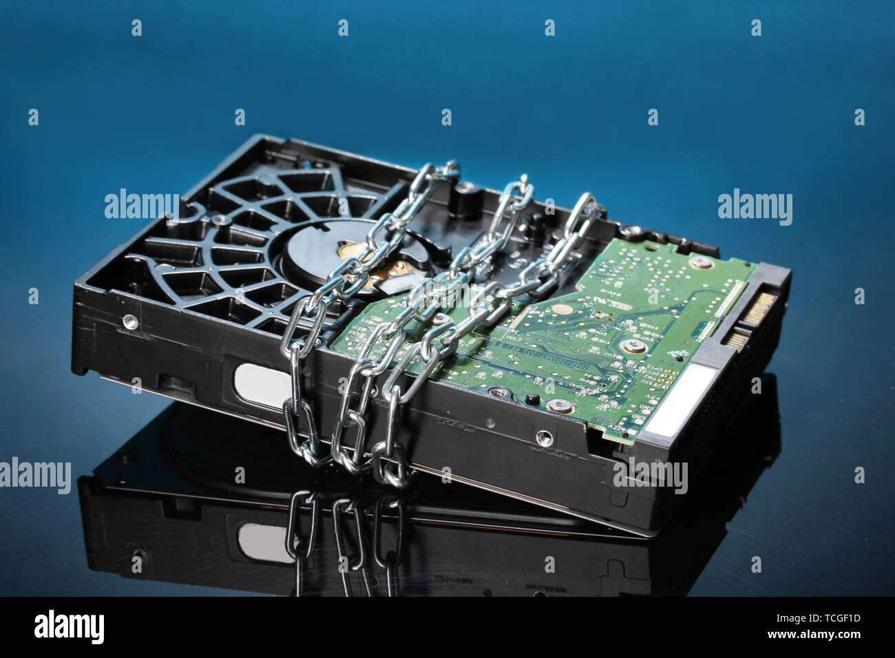 Hard disk drive on chain on dark blue background Stock Photo - Alamy
