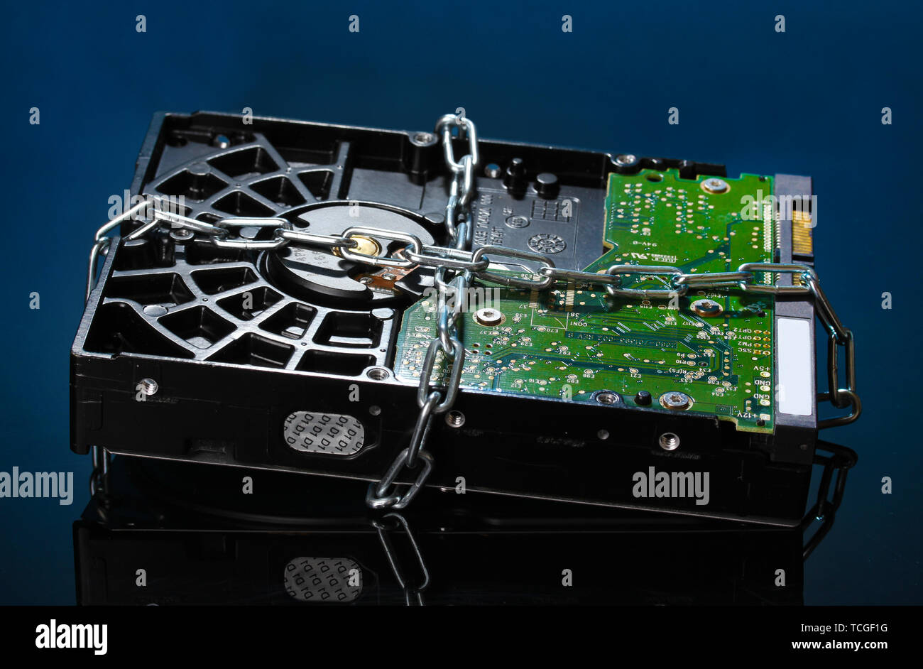 Hard disk drive on chain on dark blue background Stock Photo - Alamy
