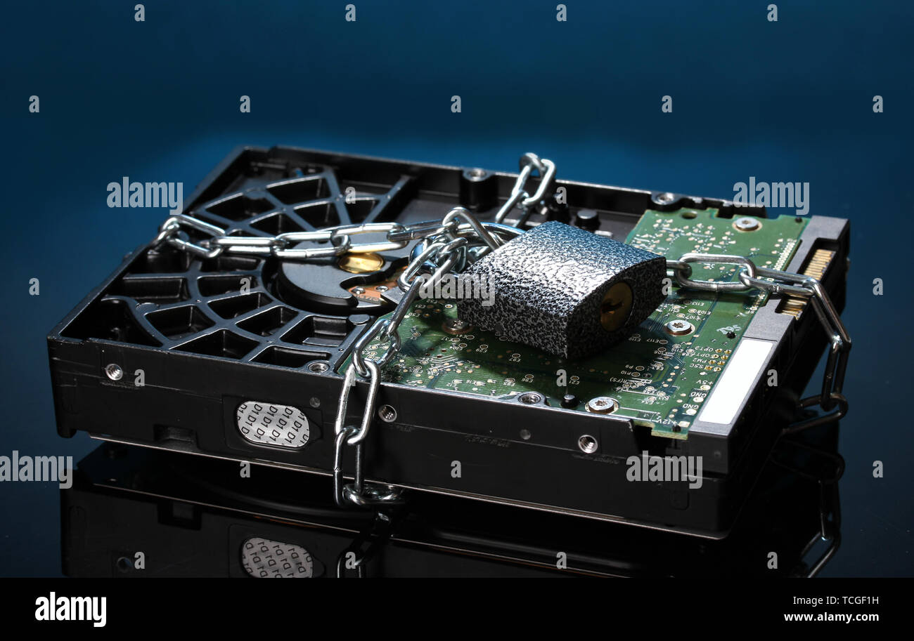 Hard disk drive on chain on dark blue background Stock Photo - Alamy