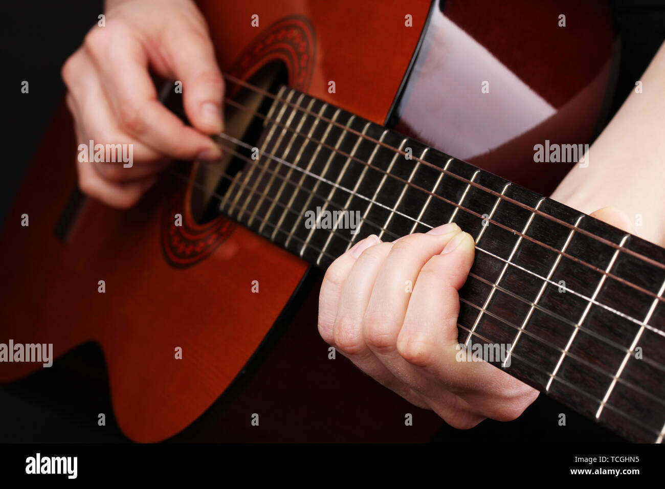 Guitar in hands isolated on black Stock Photo - Alamy