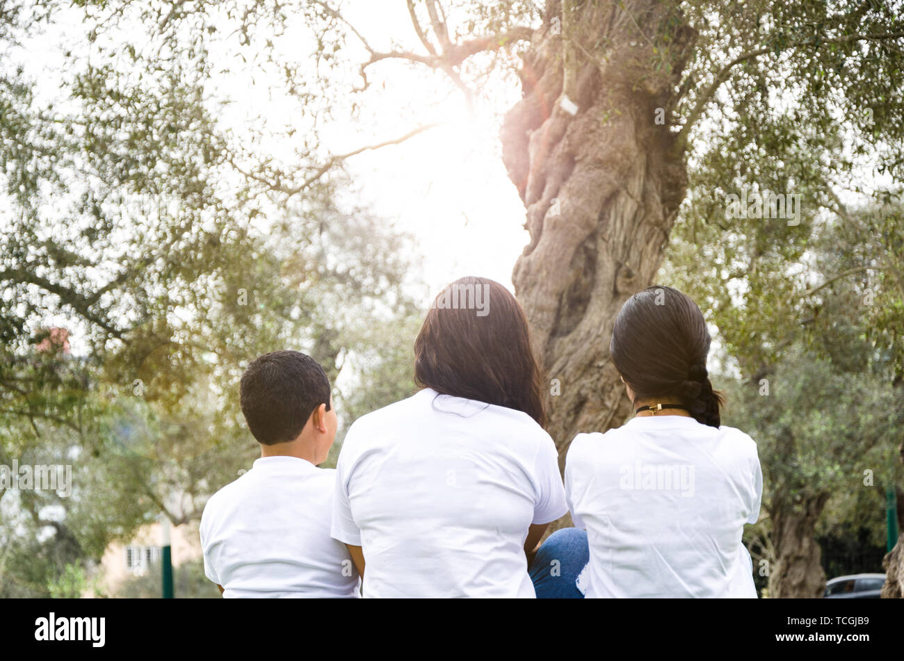 Mom with children sitting on their backs with the forest background ...