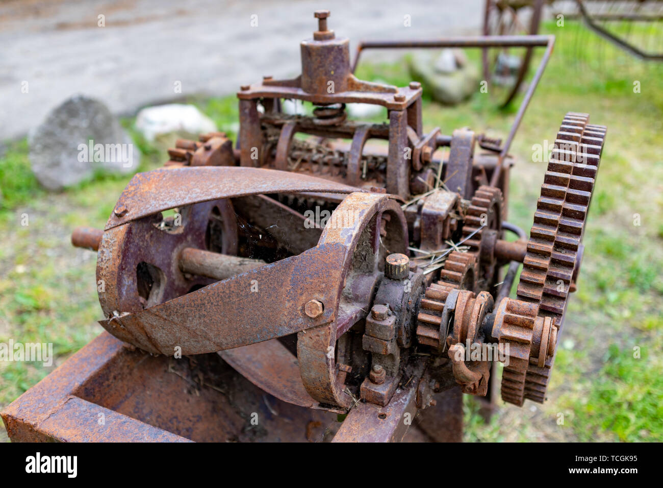 An old rusty machine used in a farm. Straw chopper in the museum. Place ...