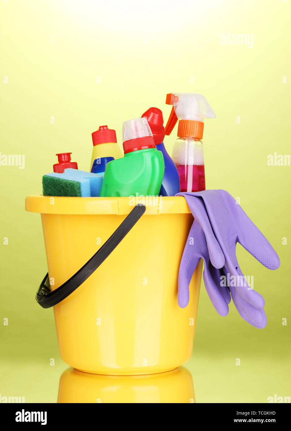 Bucket with cleaning items on green background Stock Photo - Alamy