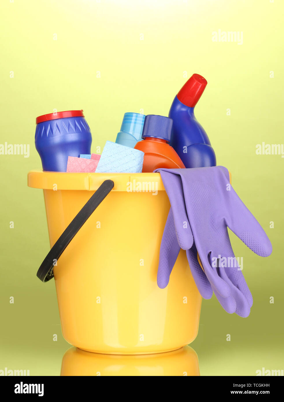 Bucket with cleaning items on green background Stock Photo - Alamy