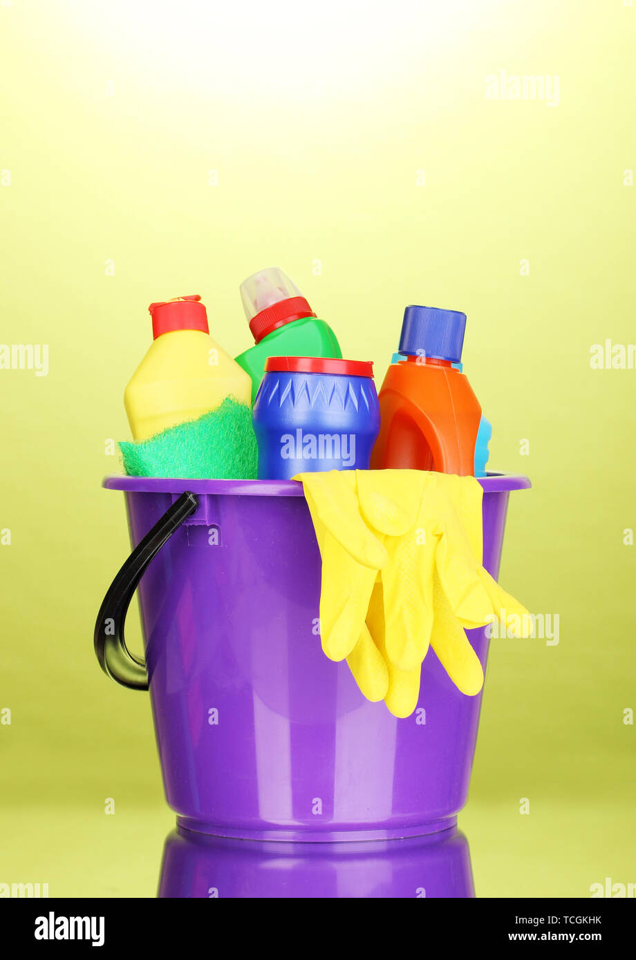 Bucket with cleaning items on green background Stock Photo - Alamy
