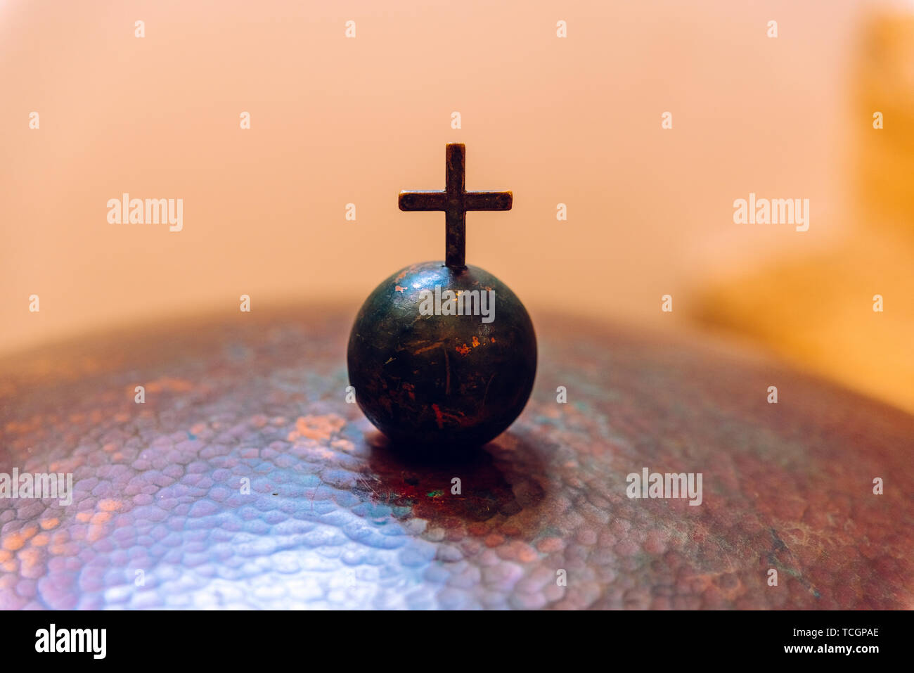 Christian cross on a small metal ball, negative space Stock Photo - Alamy