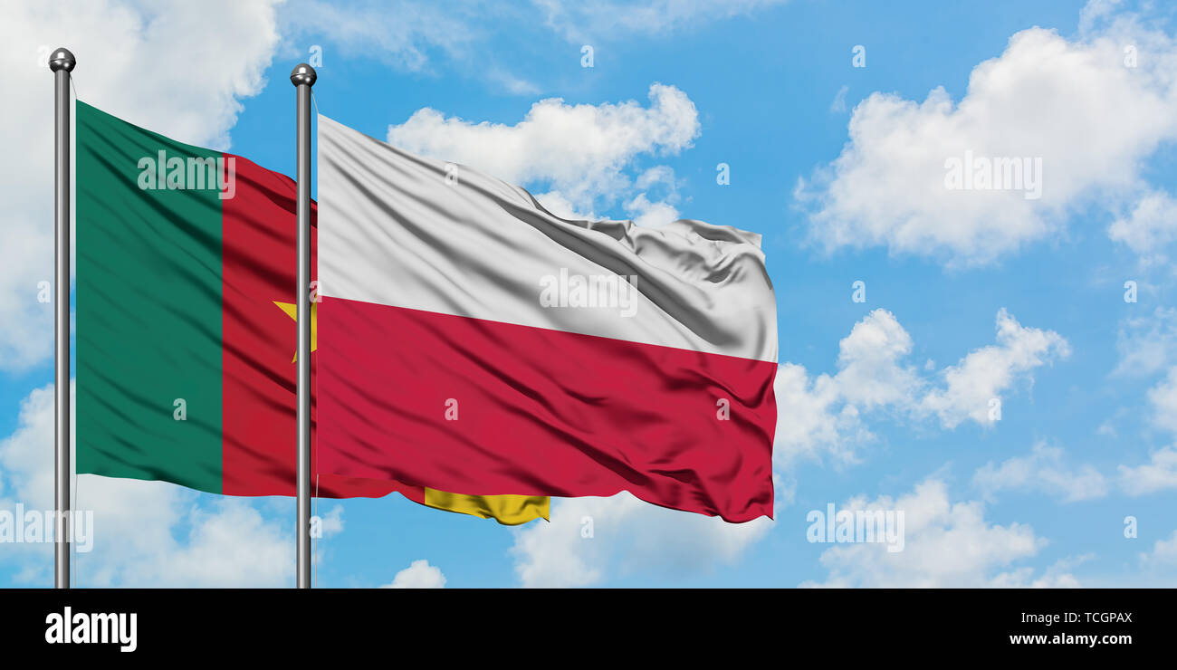 Cameroon and Poland flag waving in the wind against white cloudy blue ...
