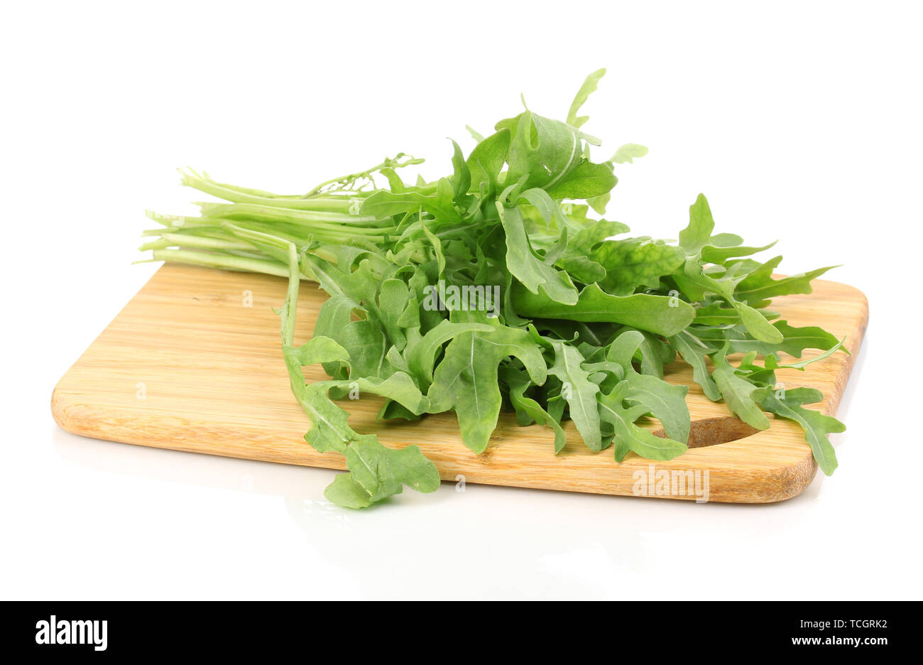 Fresh rucola salad or rocket lettuce leaves on wooden board isolated on ...
