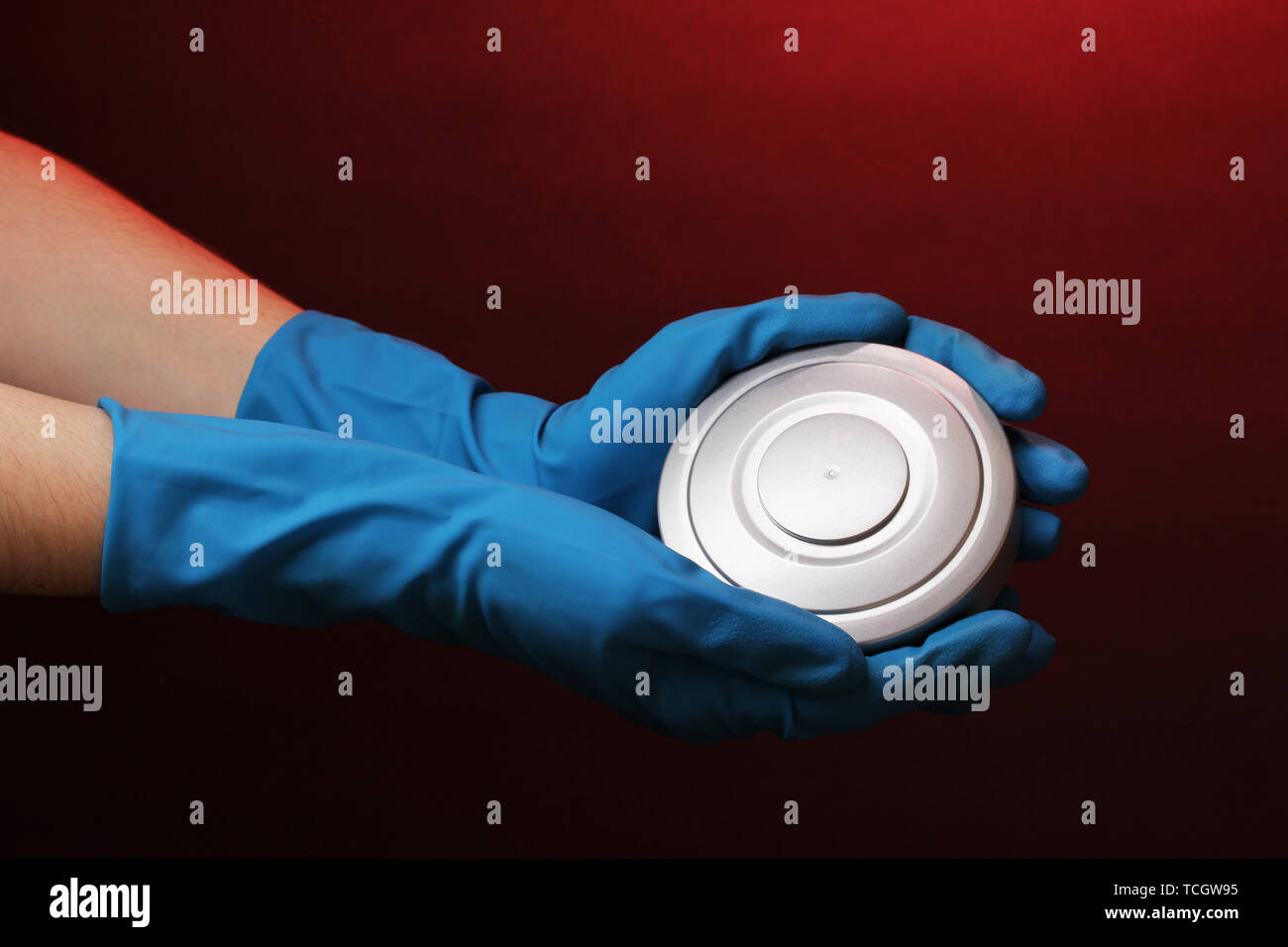 Uranium in hand on red background Stock Photo - Alamy