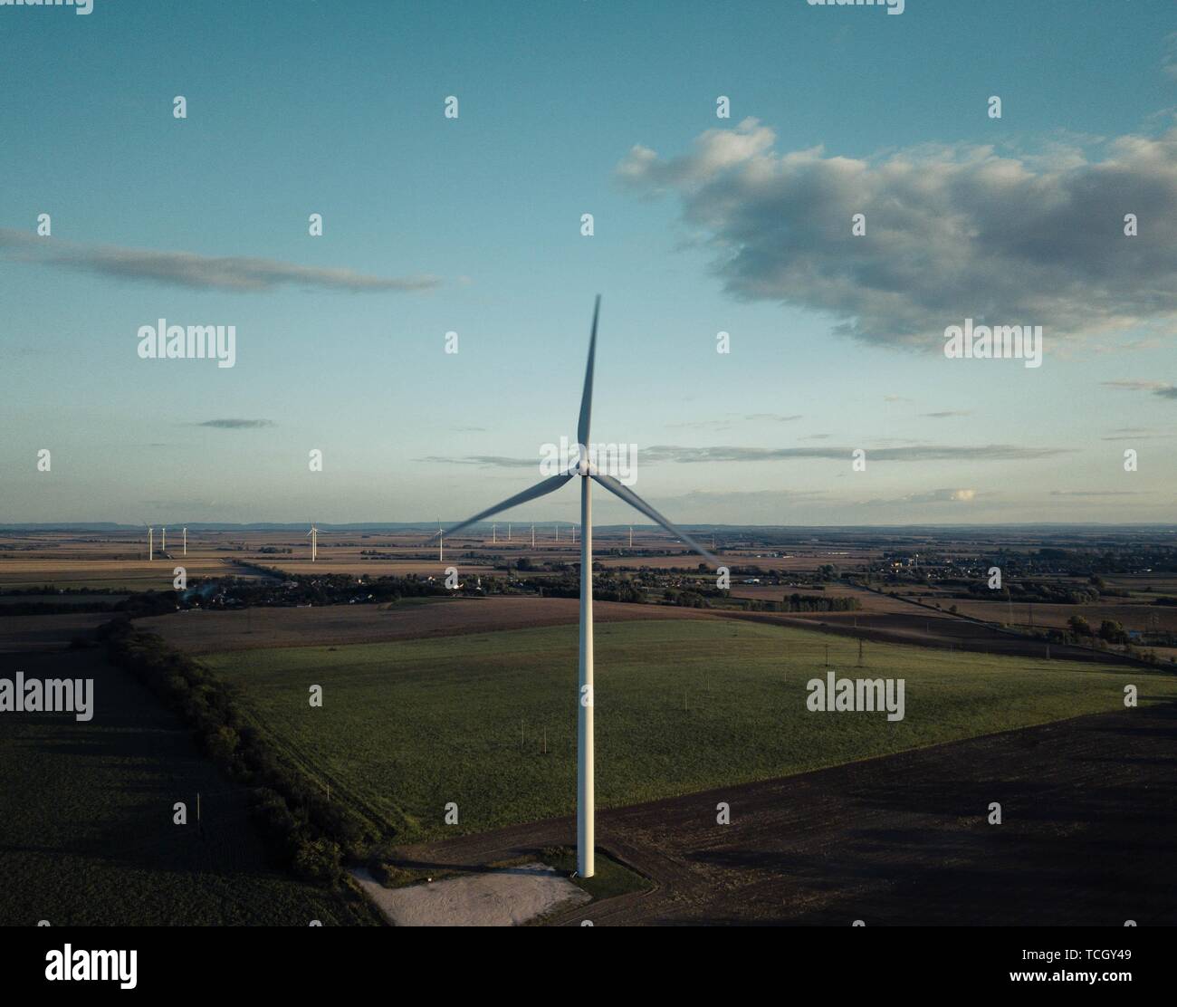 Tall wind turbine in a green field - wind energy Stock Photo - Alamy
