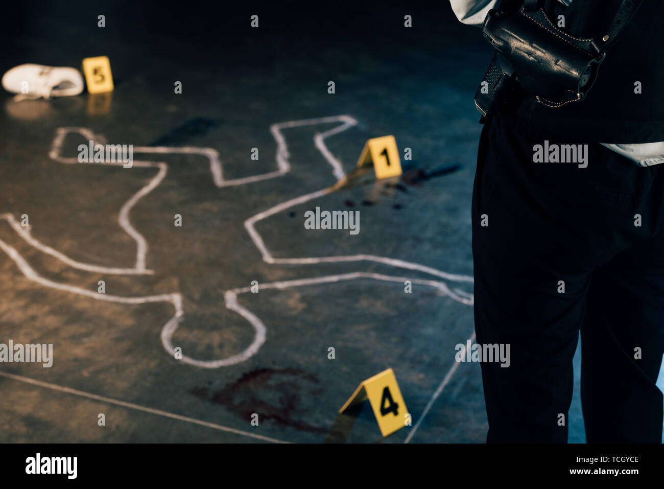 cropped view of investigator standing near chalk outline and evidence ...