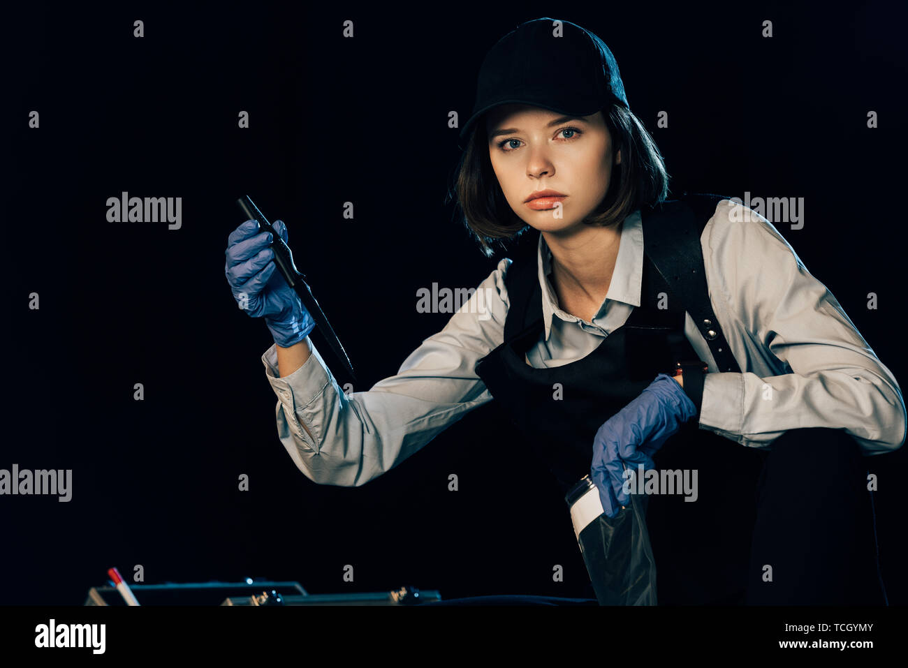 investigator in uniform holding knife and ziploc bag at crime scene ...