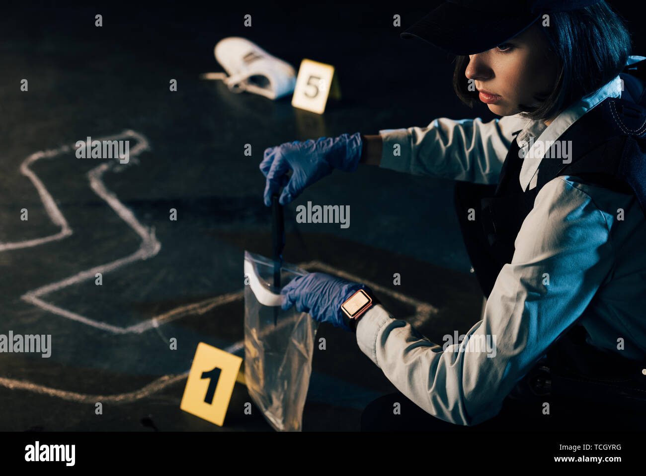 investigator in uniform gathering evidences at crime scene Stock Photo ...