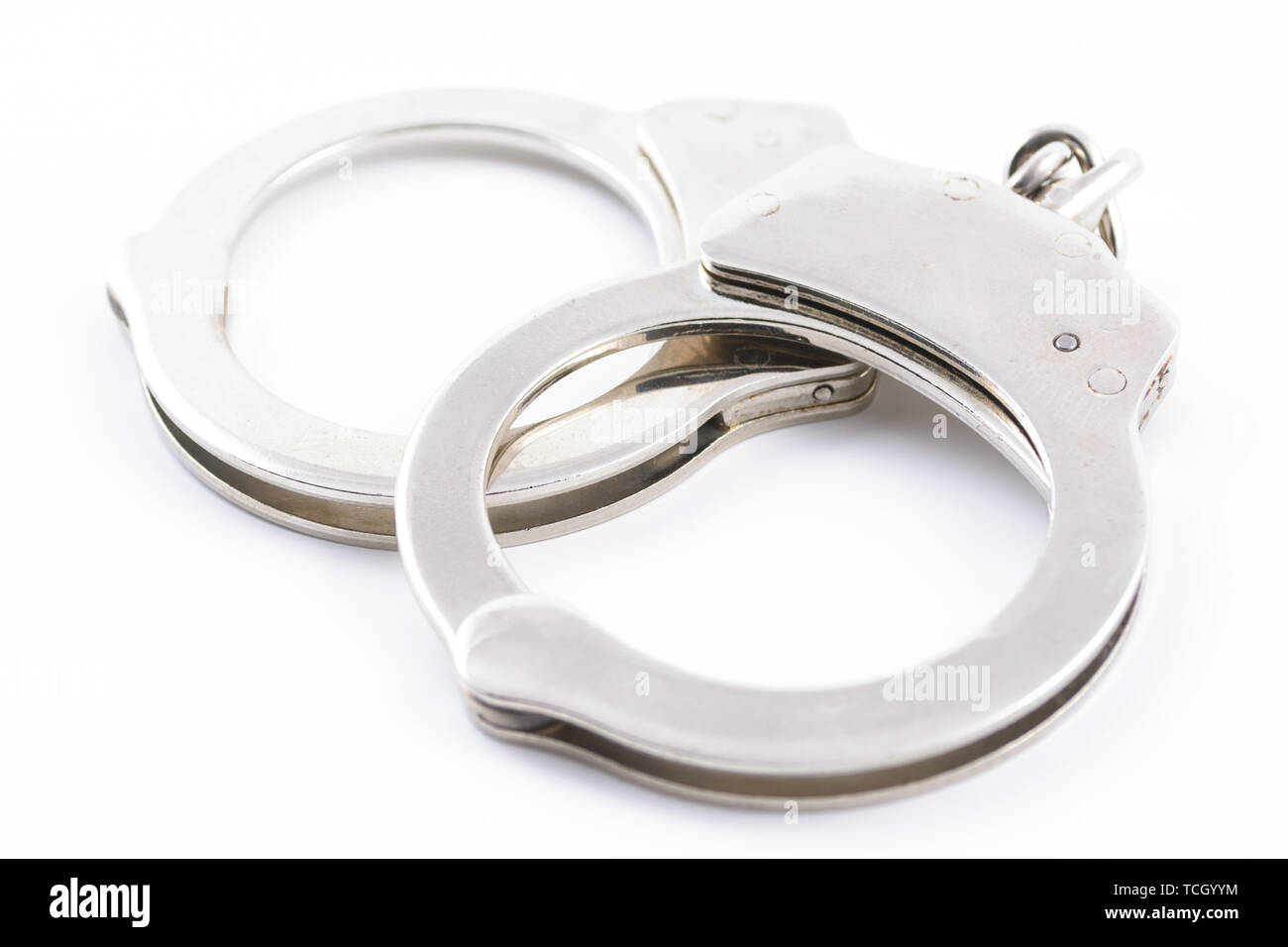 Shiny metal chrome handcuffs on a white background Stock Photo - Alamy