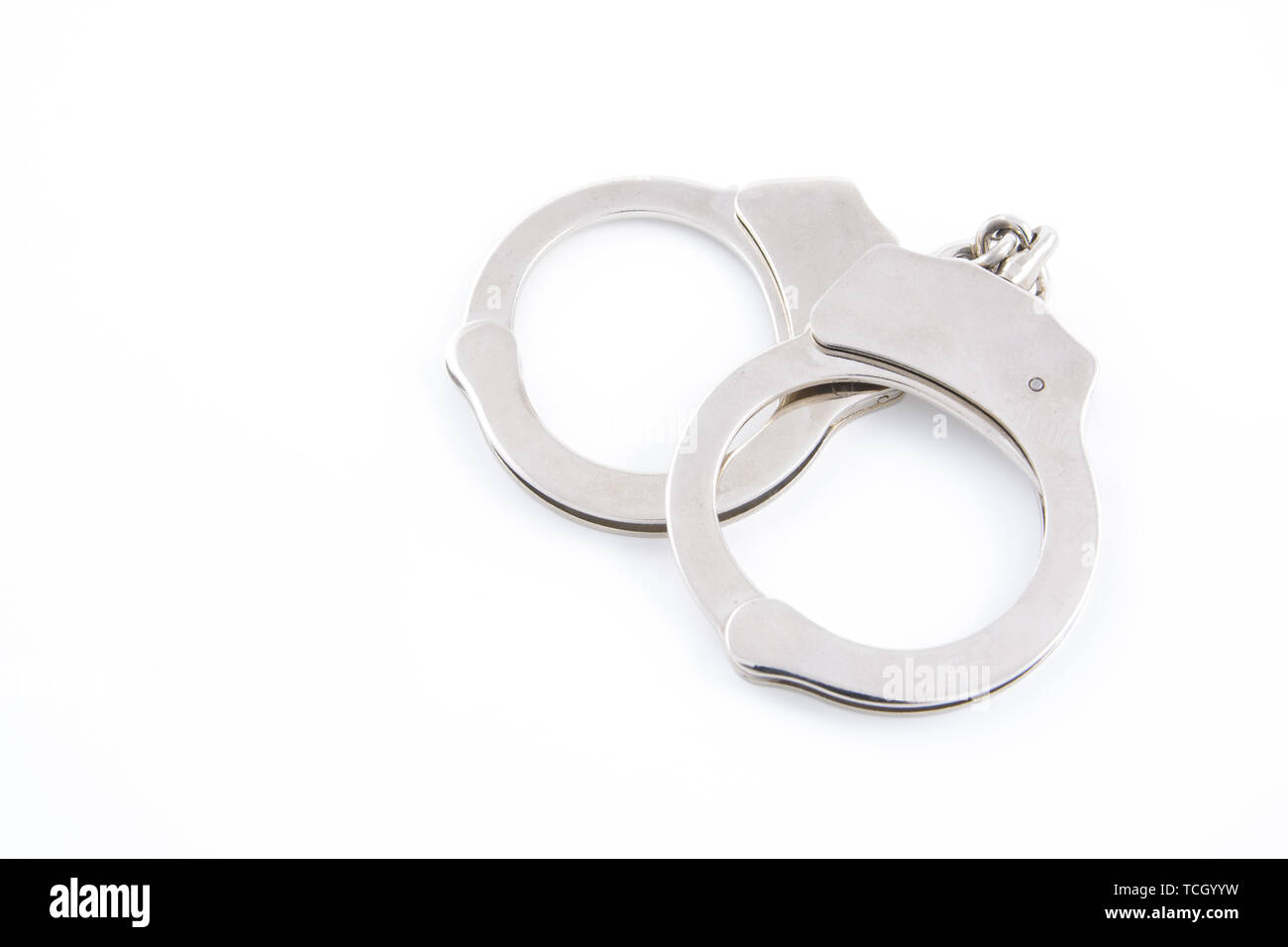 Shiny metal chrome handcuffs on a white background Stock Photo - Alamy
